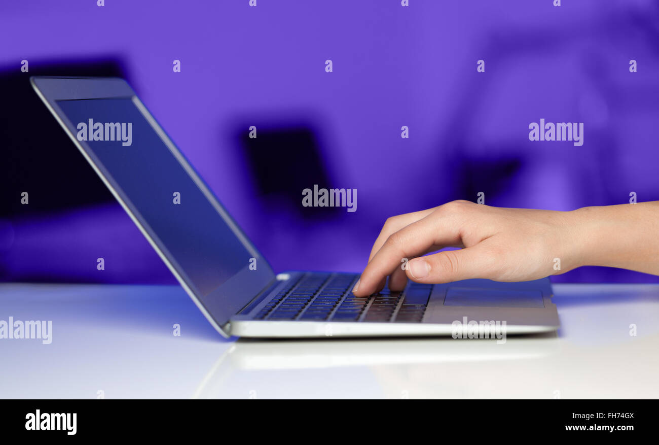 Businessman pressing modern laptop computer on colorful background ...