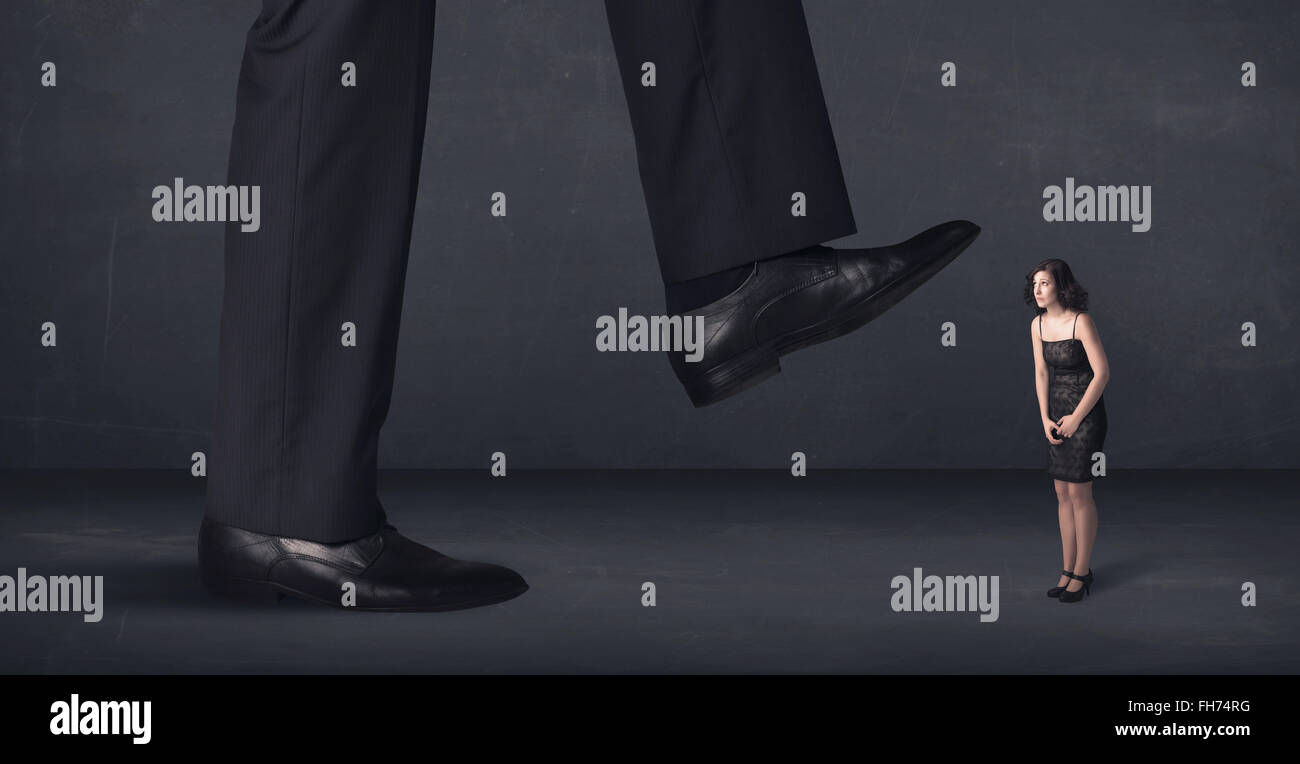 Giant person stepping on a little businesswoman concept Stock Photo - Alamy