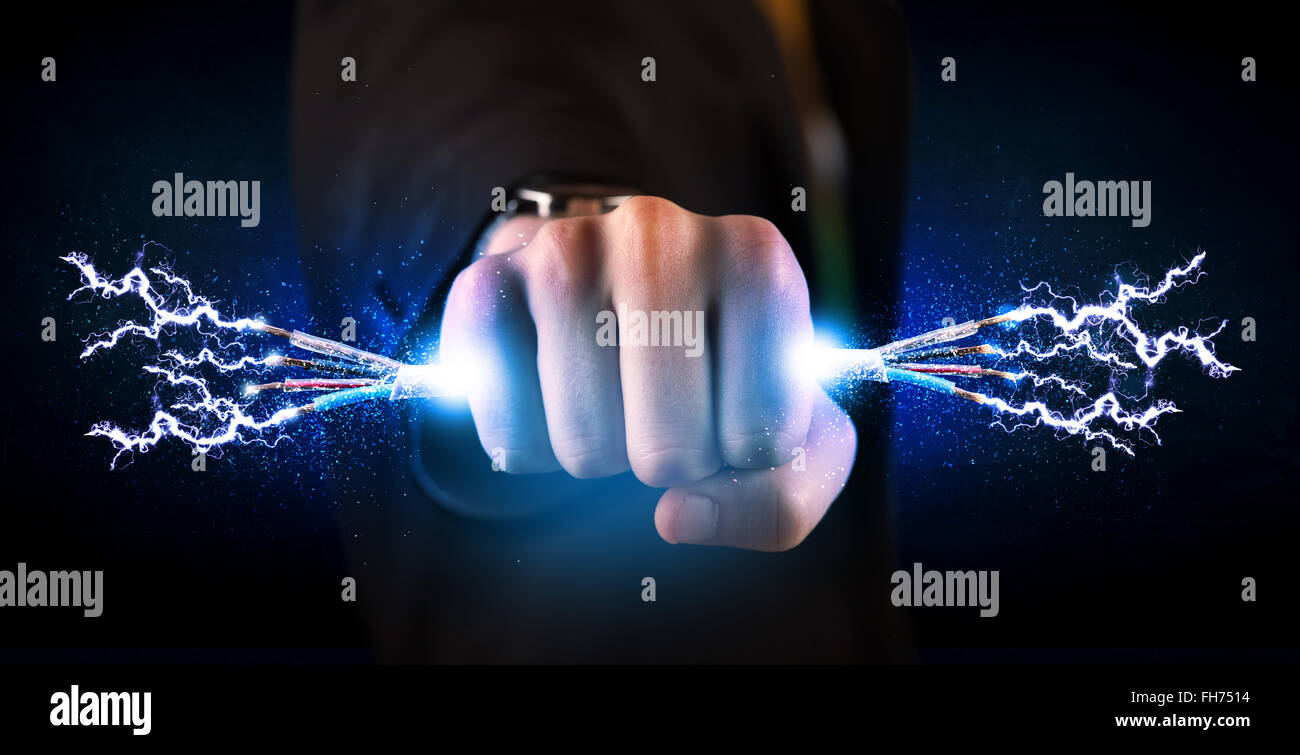 Business person holding electrical powered wires Stock Photo - Alamy