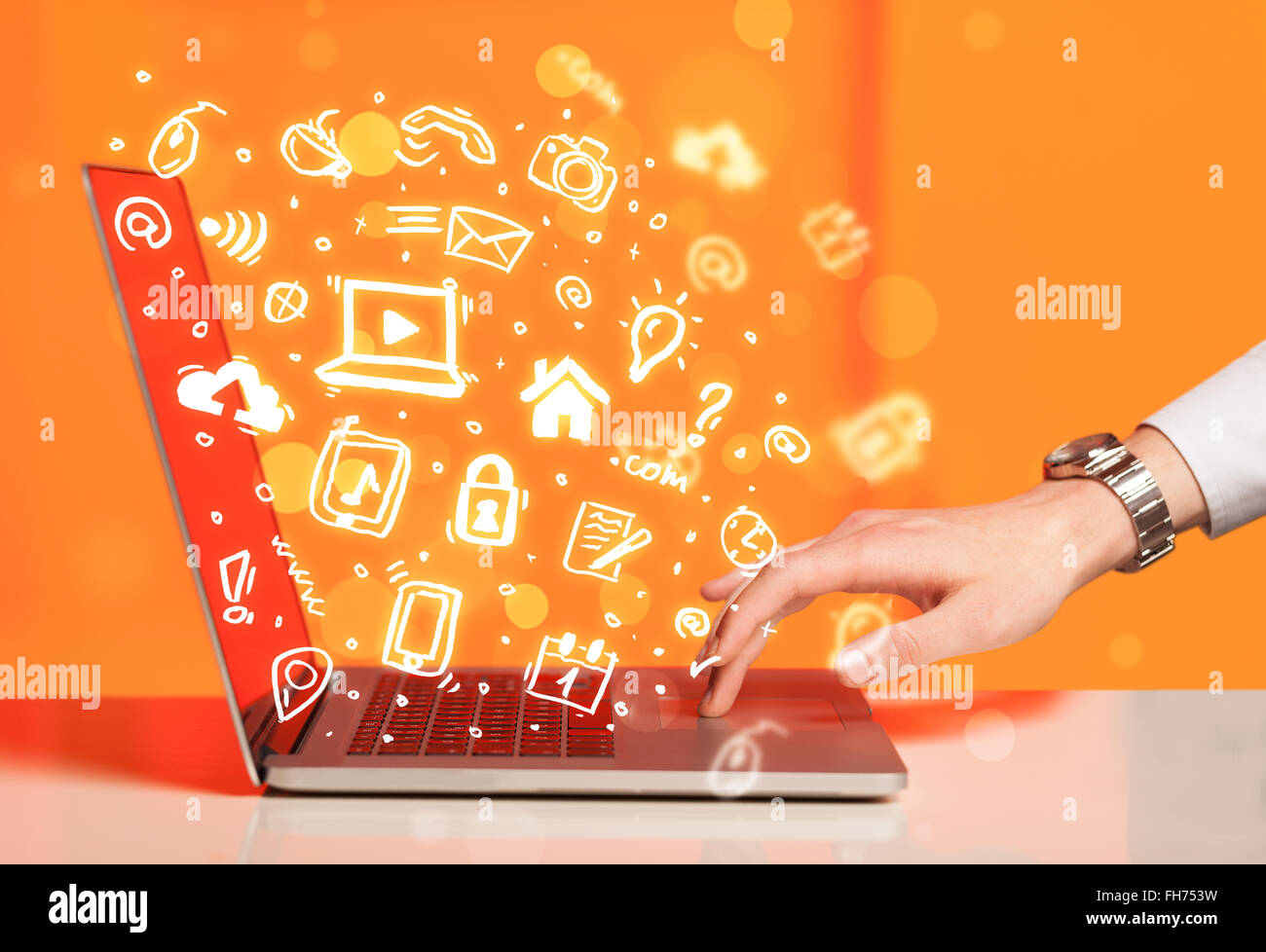 Hand writing on notebook computer with media icons and symbols Stock ...