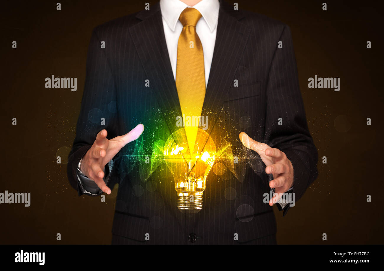 Businessman holding light bulb Stock Photo - Alamy