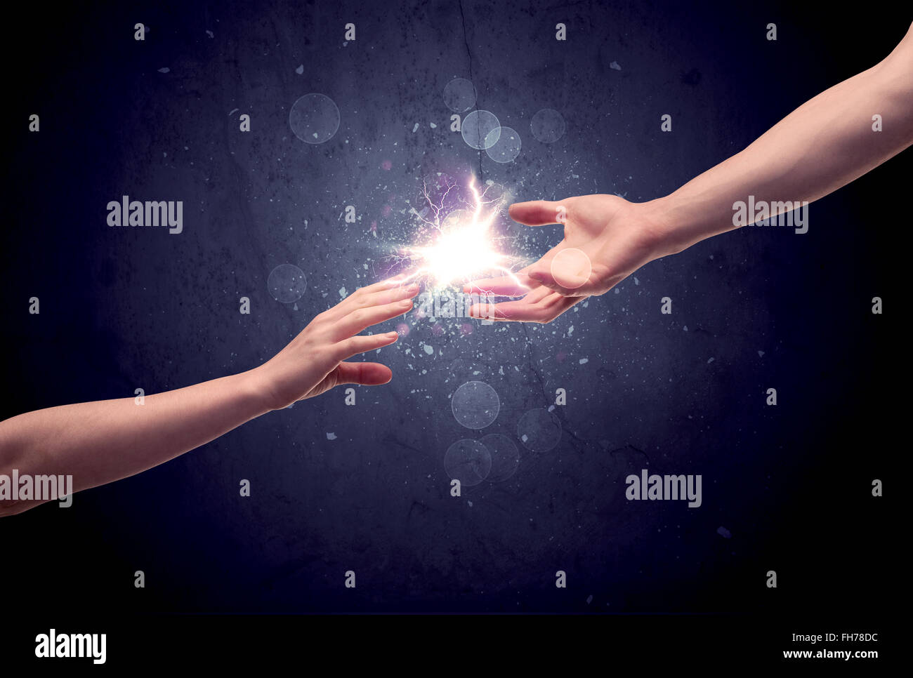 Hands reaching to light a spark Stock Photo - Alamy