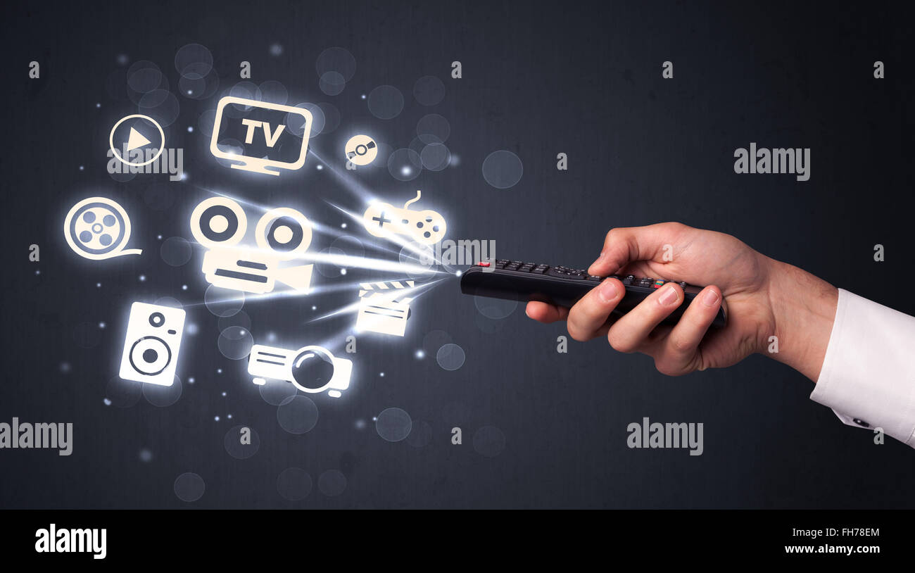 Hand with remote control and media icons Stock Photo - Alamy