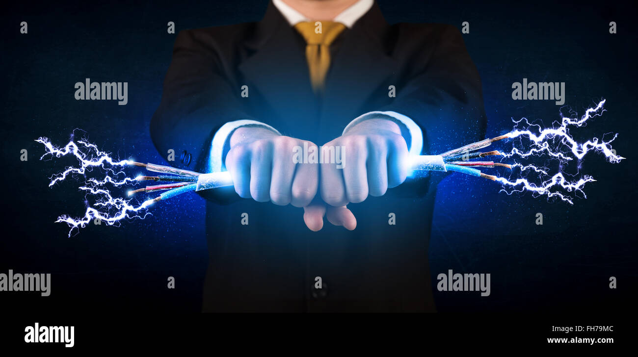 Business person holding electrical powered wires Stock Photo - Alamy