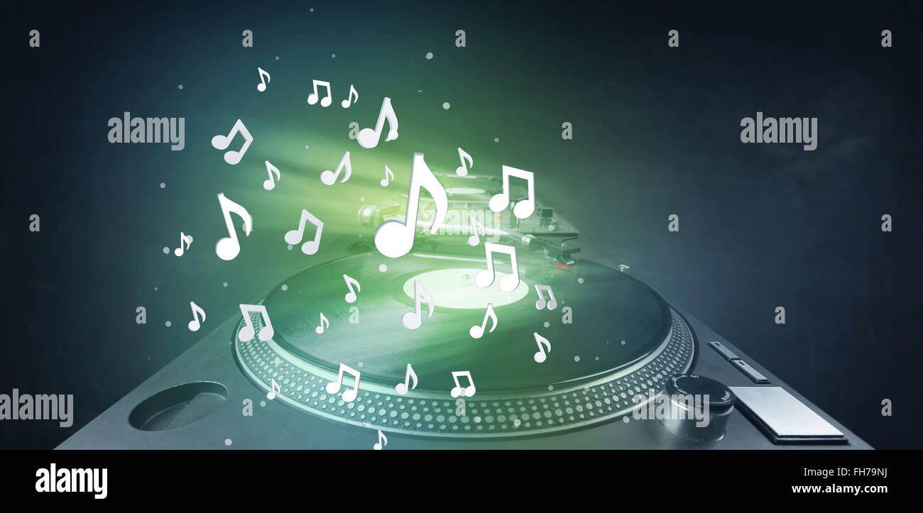Turntable playing music with audio notes glowing Stock Photo - Alamy
