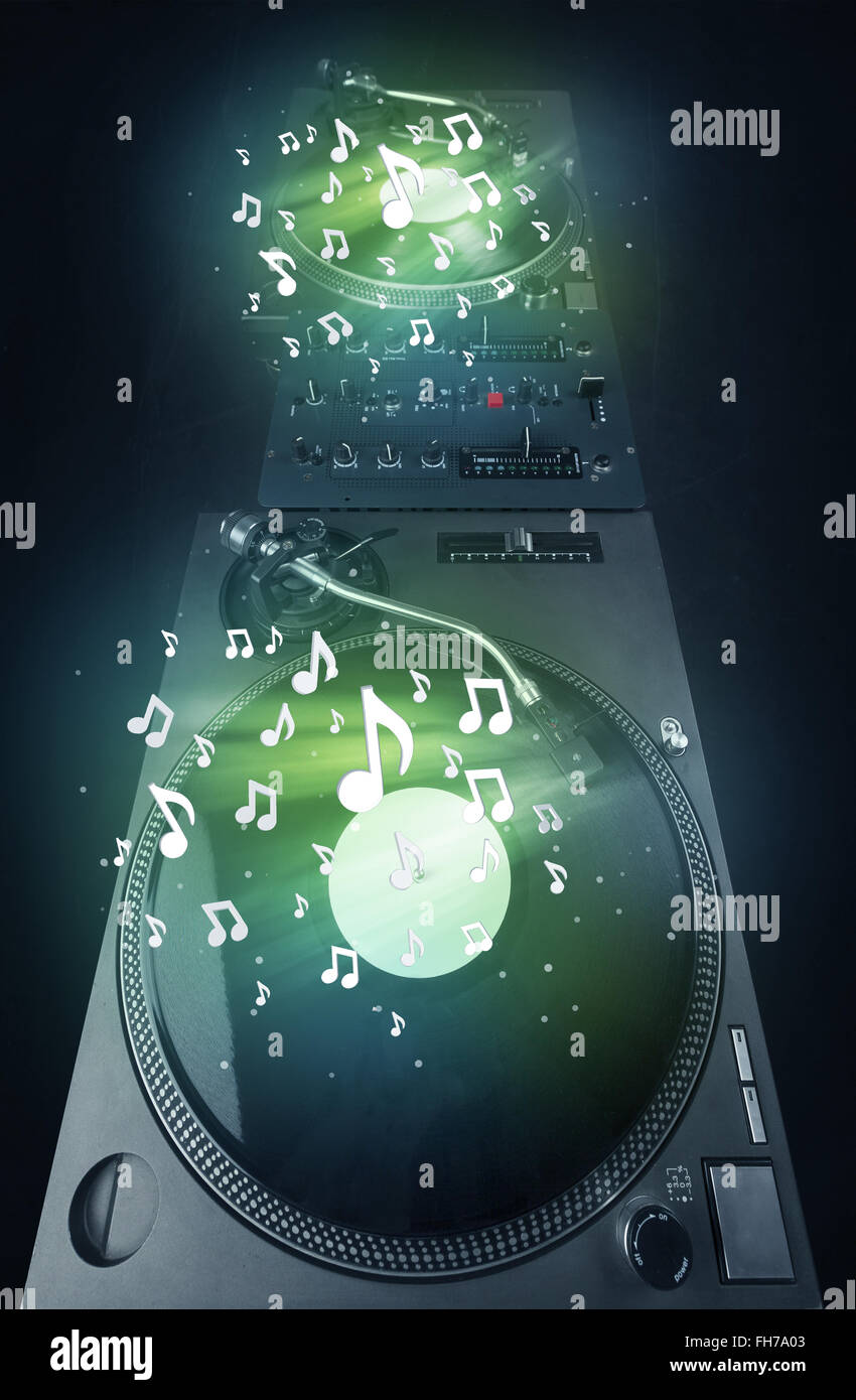 Turntable playing music with audio notes glowing Stock Photo - Alamy