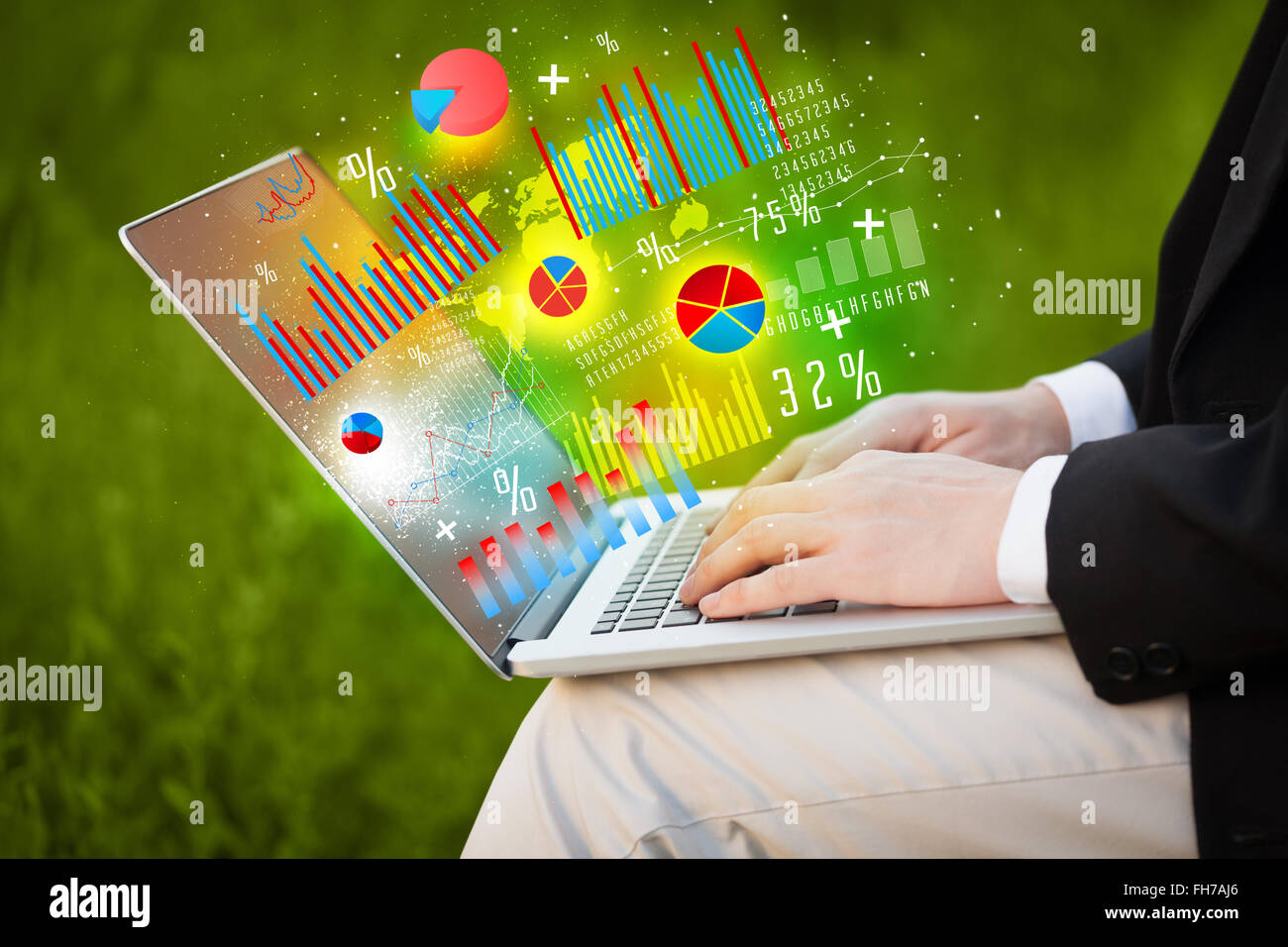 Hand typing on modern laptop notebook computer with graph icons and ...