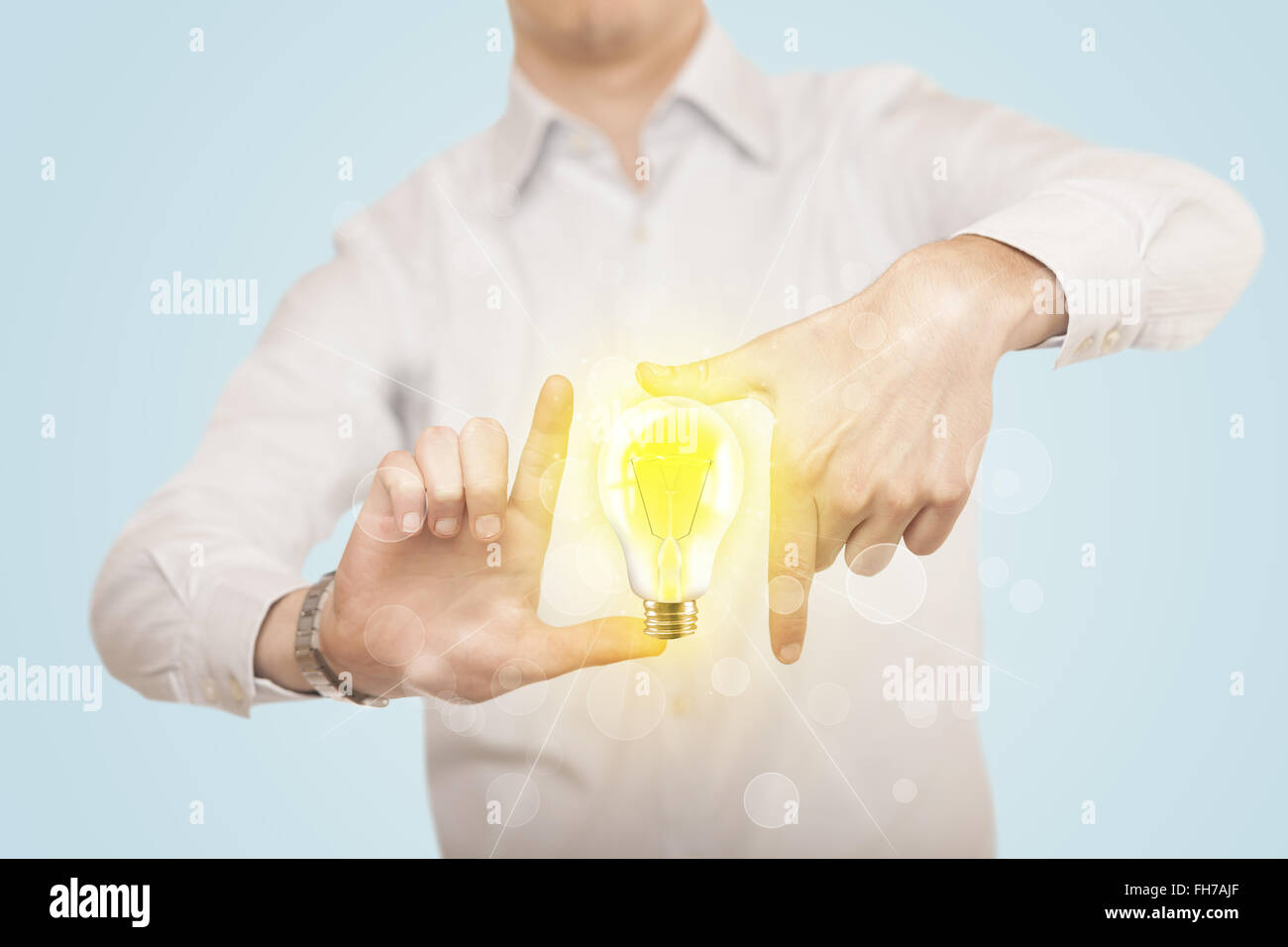 Hands creating a form with light bulb Stock Photo - Alamy