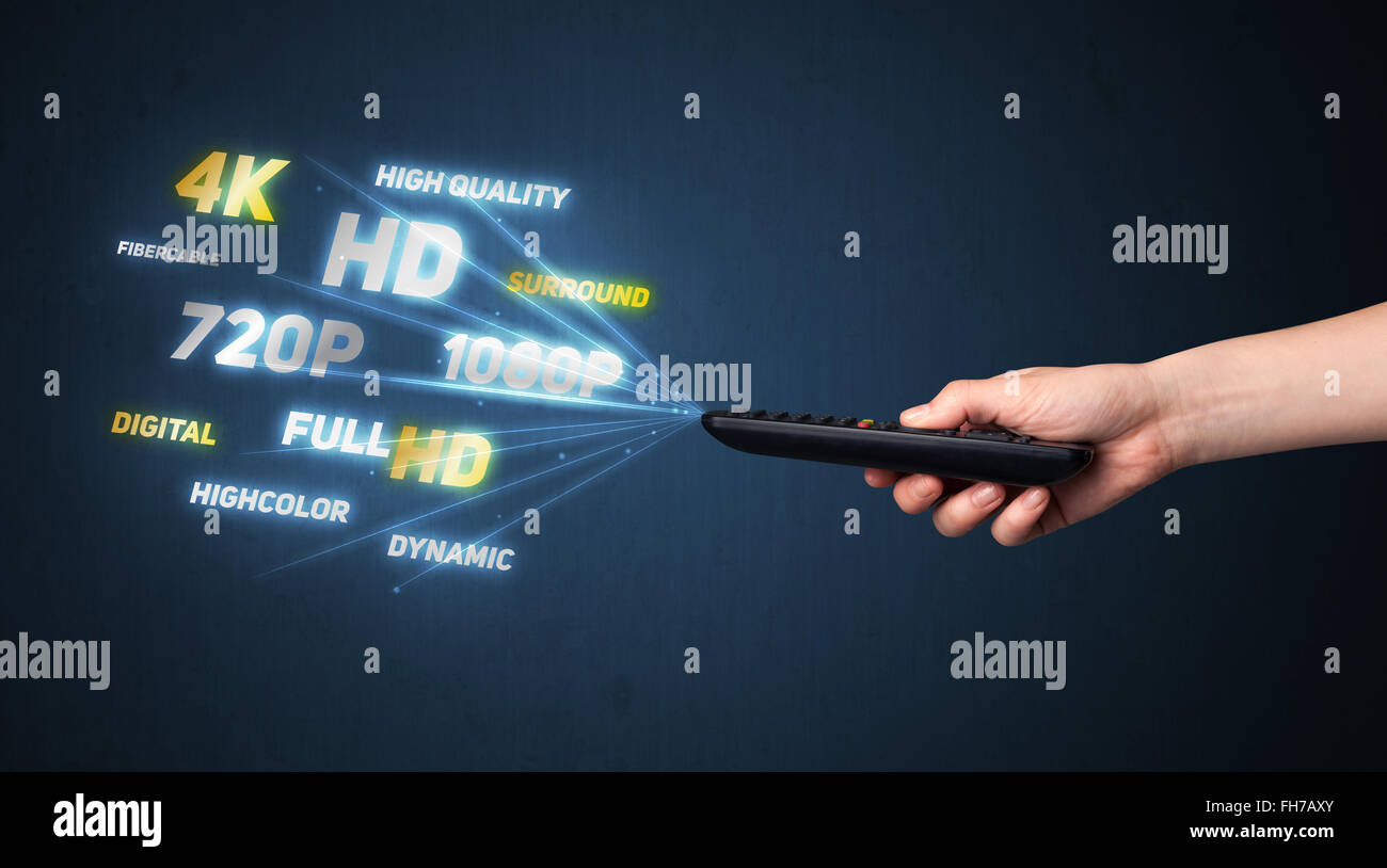 Hand with remote control and multimedia properties Stock Photo - Alamy