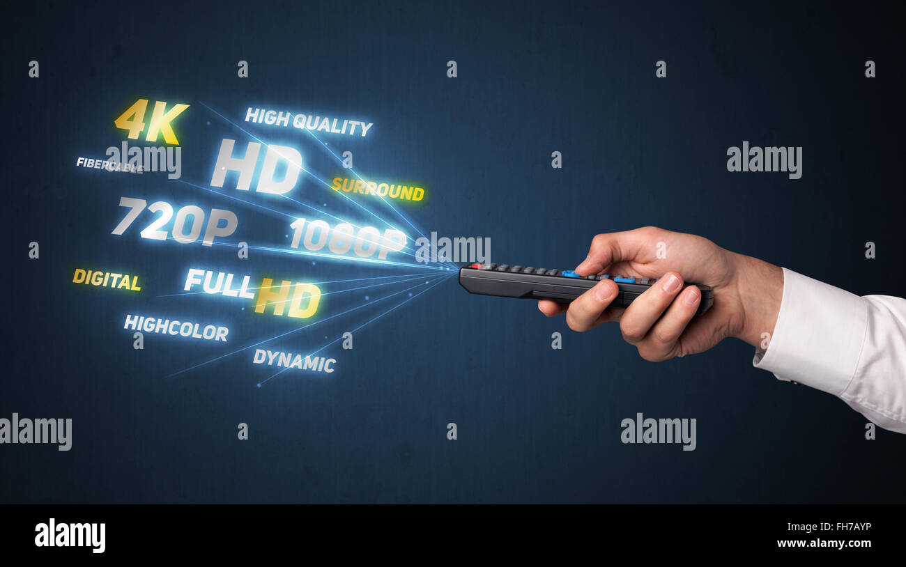 Hand with remote control and multimedia properties Stock Photo - Alamy