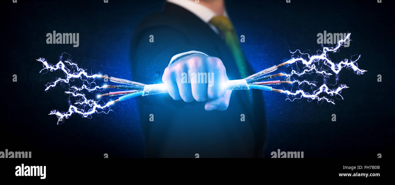 Business person holding electrical powered wires Stock Photo - Alamy