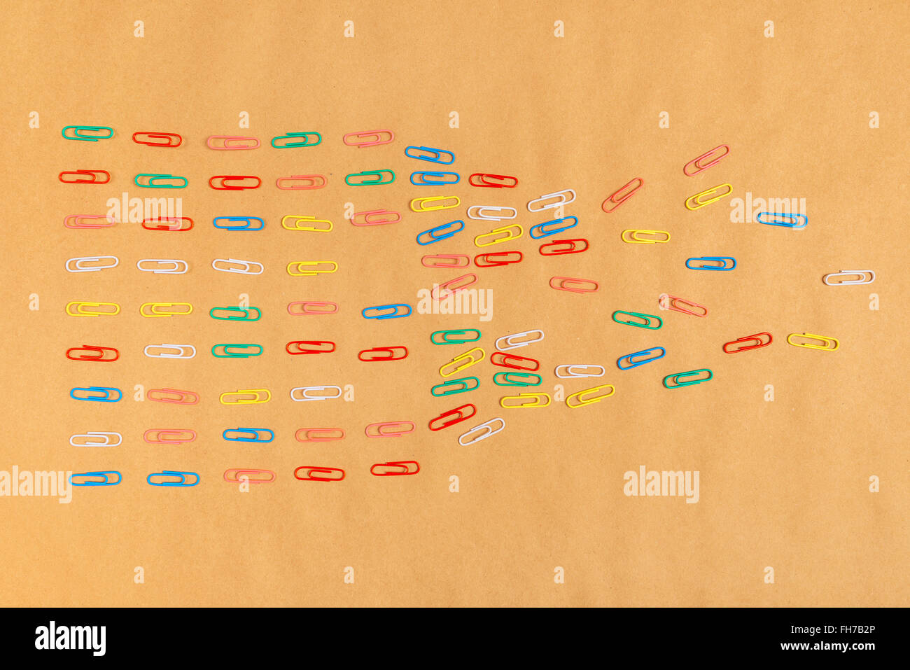 Flat lay colorful paper clips arrangement on kraft paper background ...
