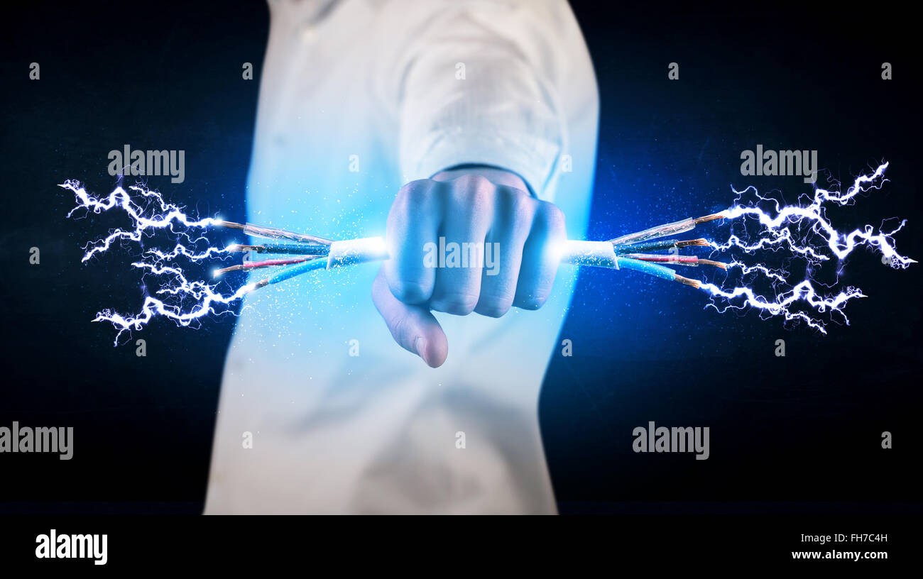 Business person holding electrical powered wires Stock Photo - Alamy
