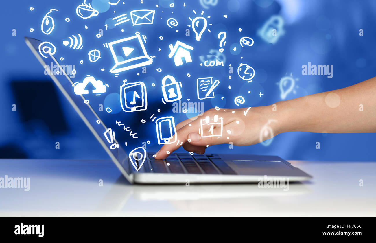 Hand writing on notebook computer with media icons and symbols Stock ...