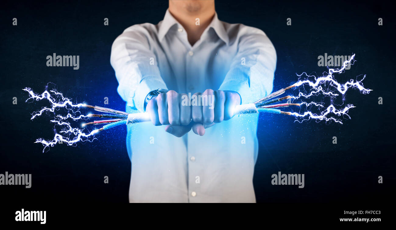 Business person holding electrical powered wires Stock Photo - Alamy