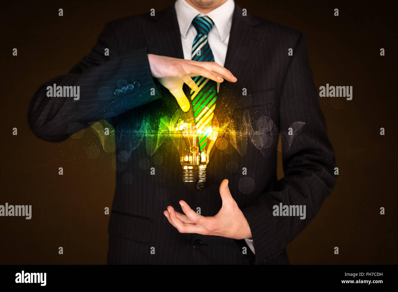 Businessman holding light bulb Stock Photo - Alamy