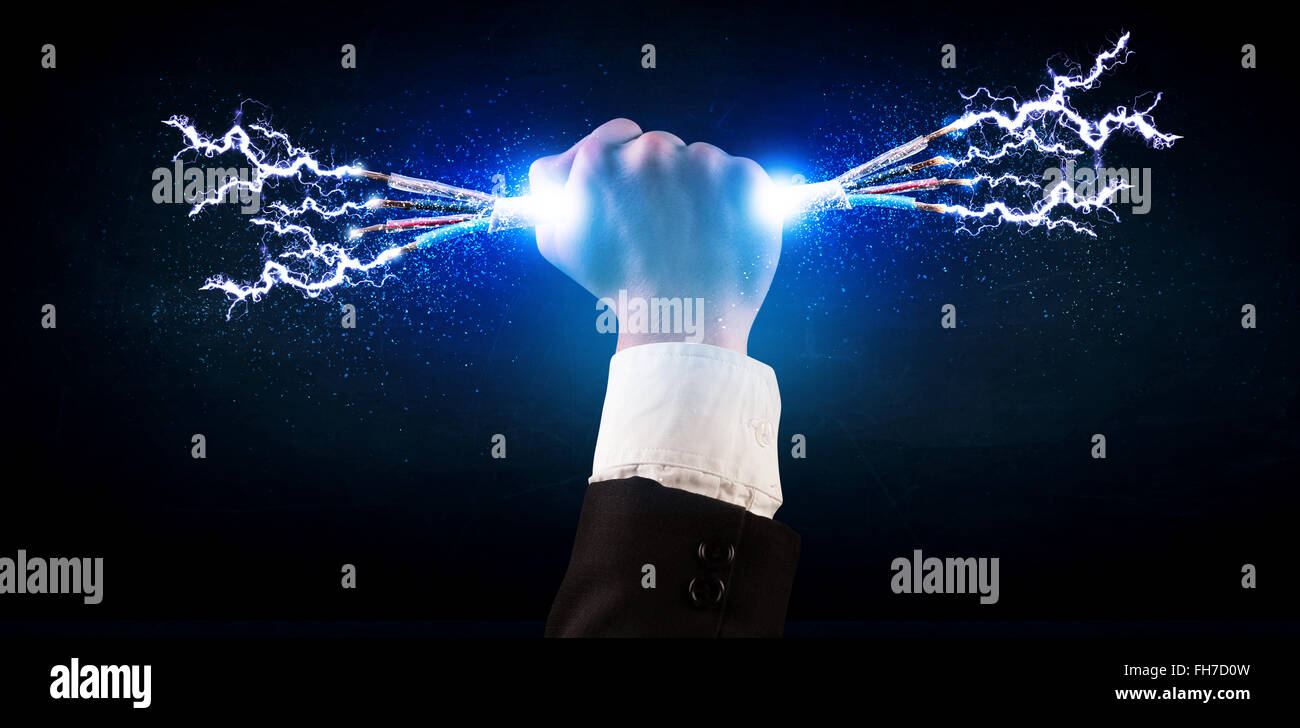 Business person holding electrical powered wires Stock Photo - Alamy