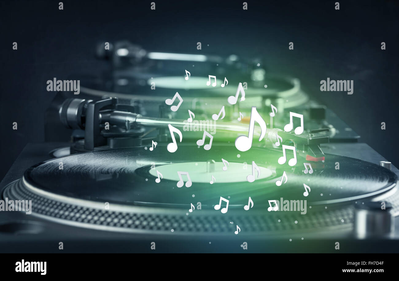 Turntable playing music with audio notes glowing Stock Photo - Alamy