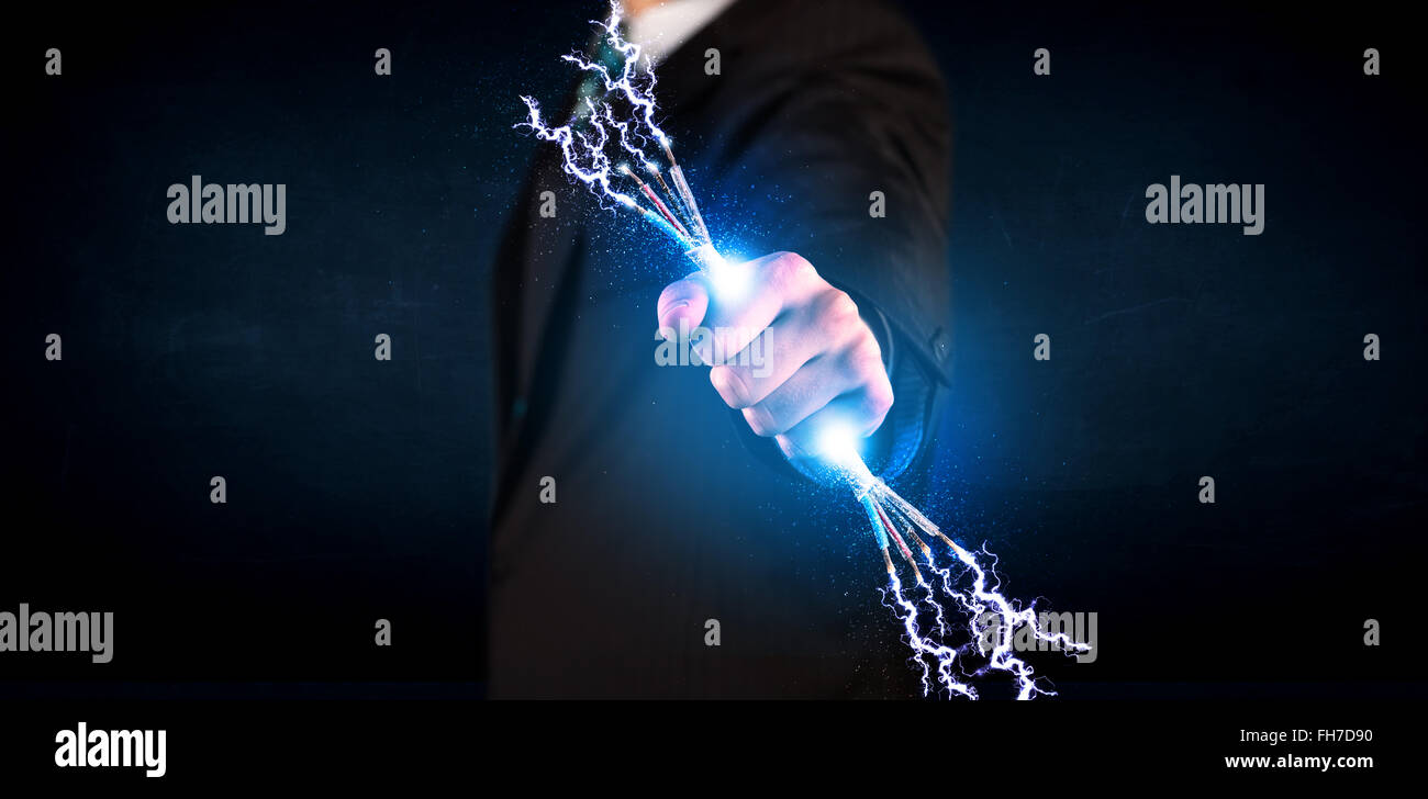 Business person holding electrical powered wires Stock Photo - Alamy