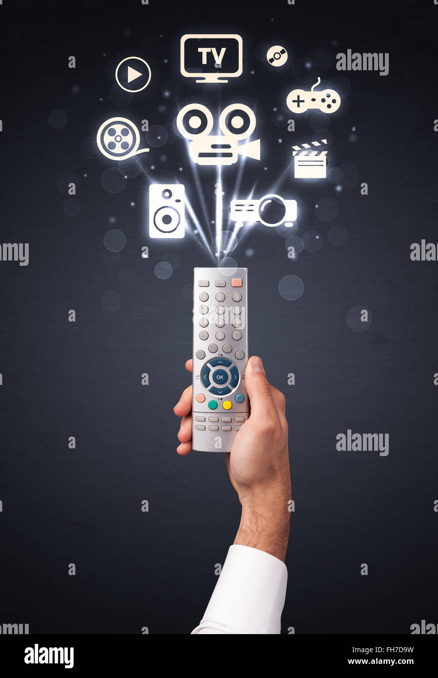 Hand with remote control and media icons Stock Photo - Alamy