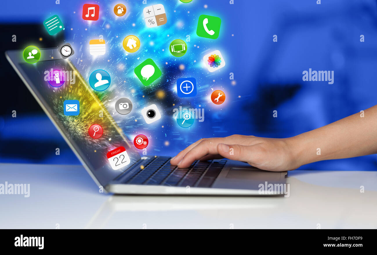 Hand pressing modern laptop with mobile app icons and symbols Stock ...