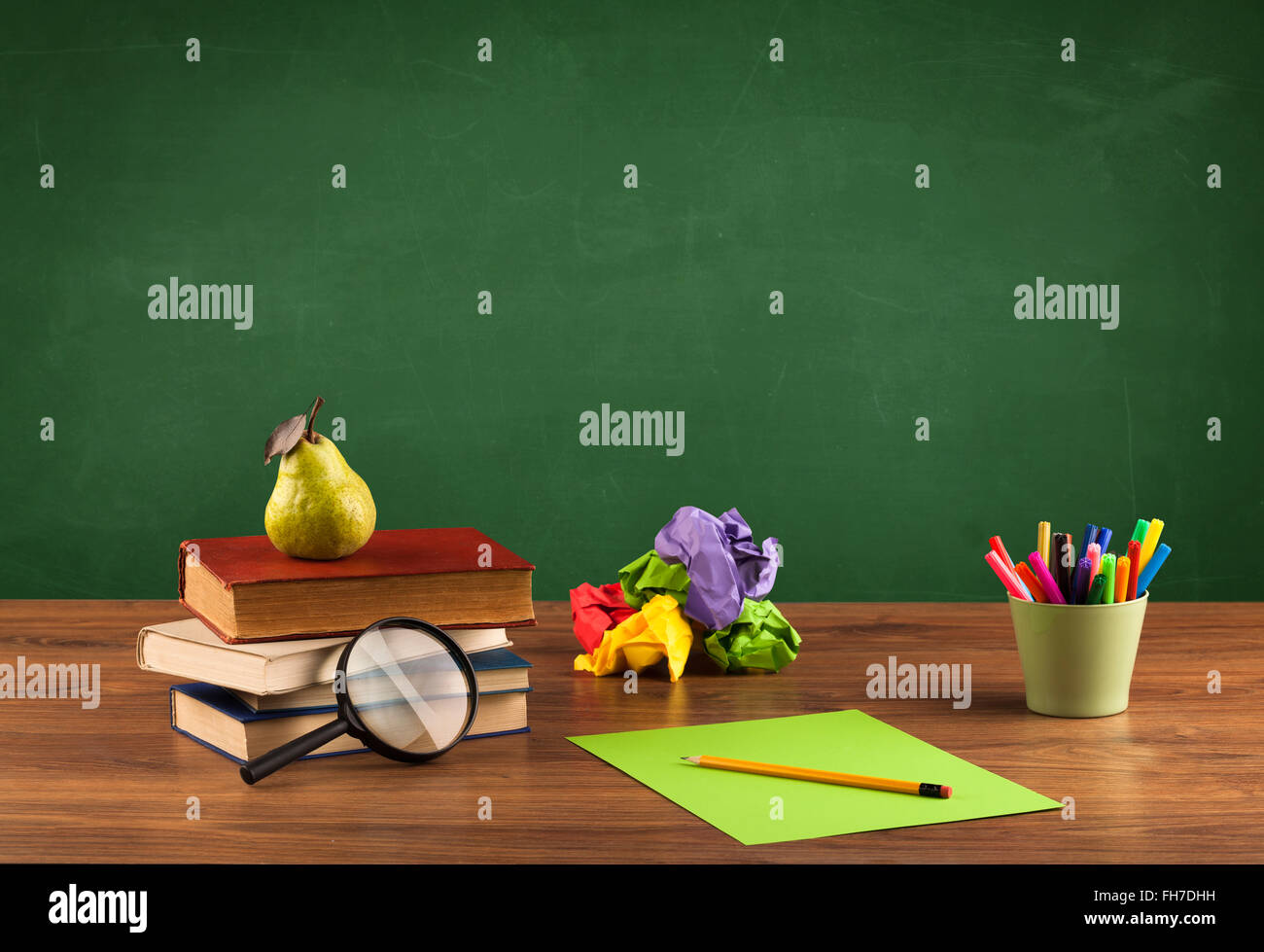 School items on desk with empty chalkboard Stock Photo - Alamy
