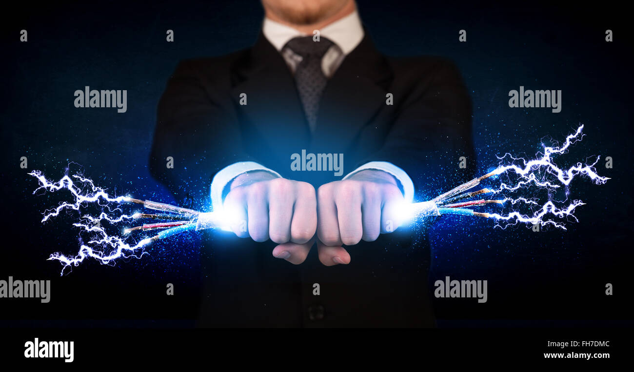 Business person holding electrical powered wires Stock Photo - Alamy