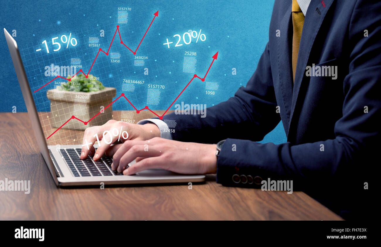 Salesman working on graph with laptop Stock Photo - Alamy
