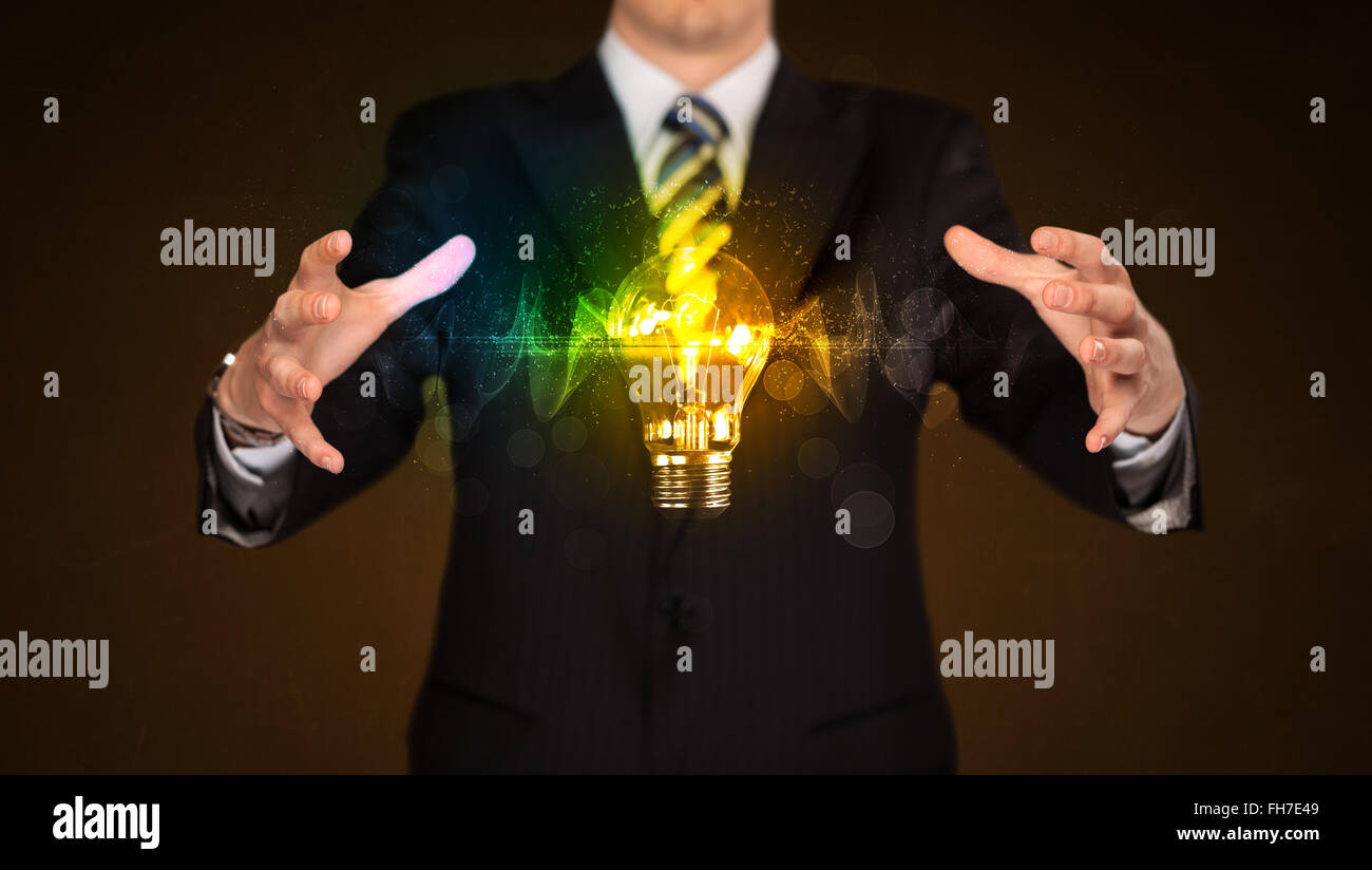 Businessman holding light bulb Stock Photo - Alamy