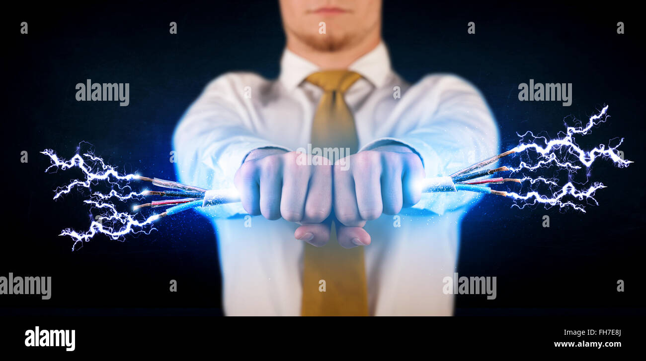 Business person holding electrical powered wires Stock Photo - Alamy