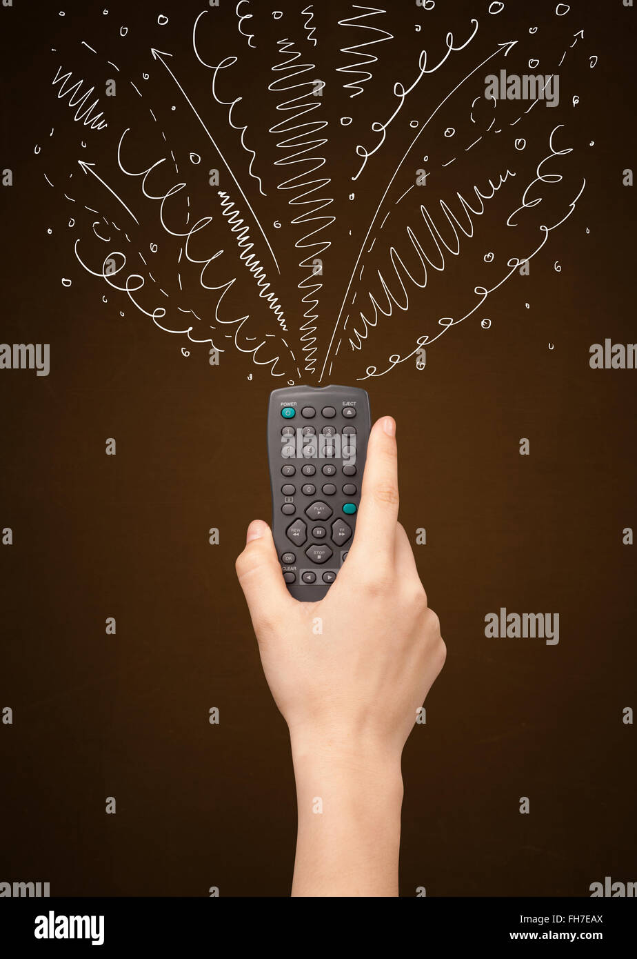 Hand with remote control and curly lines Stock Photo - Alamy