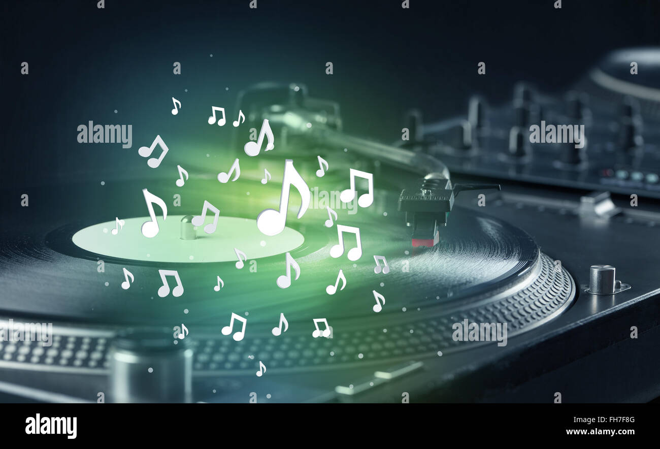 Turntable playing music with audio notes glowing Stock Photo - Alamy