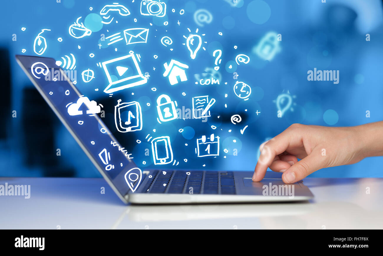 Hand writing on notebook computer with media icons and symbols Stock ...