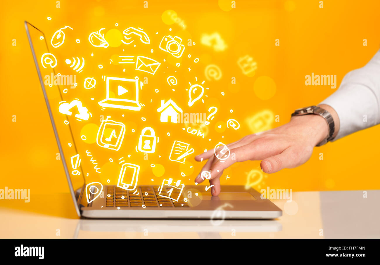 Hand writing on notebook computer with media icons and symbols Stock ...