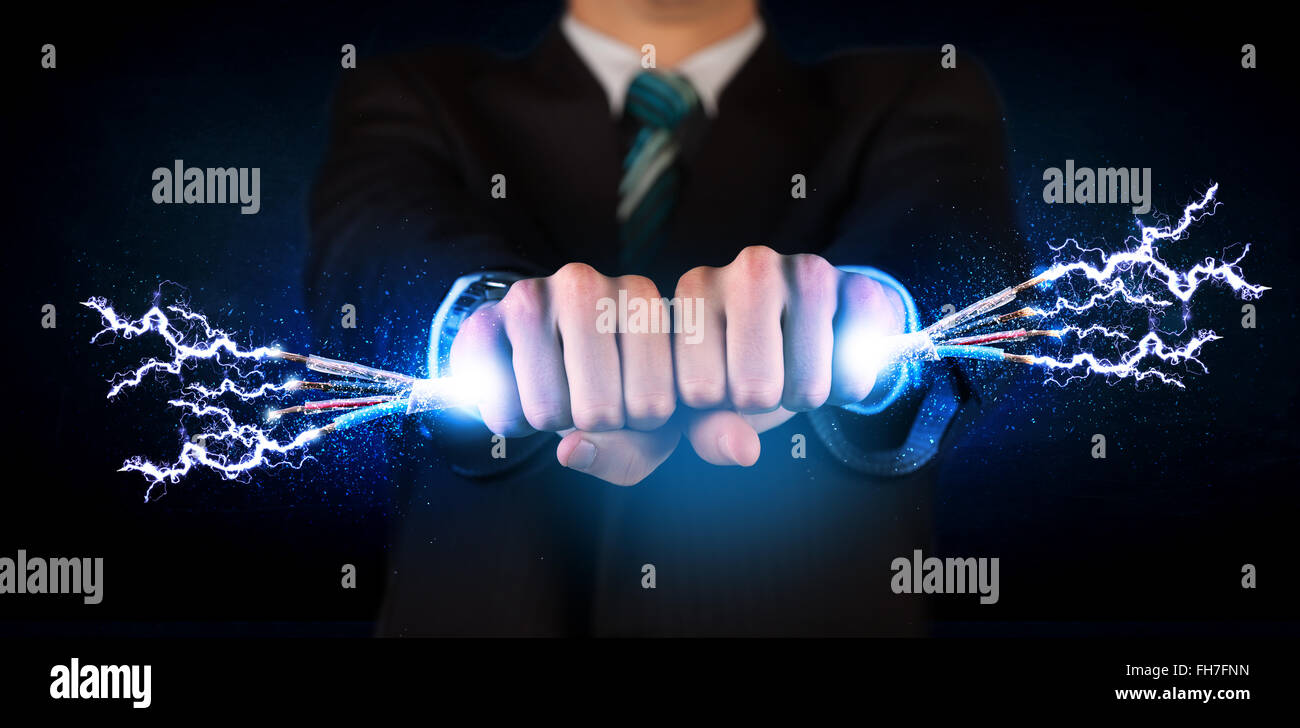 Business person holding electrical powered wires Stock Photo - Alamy