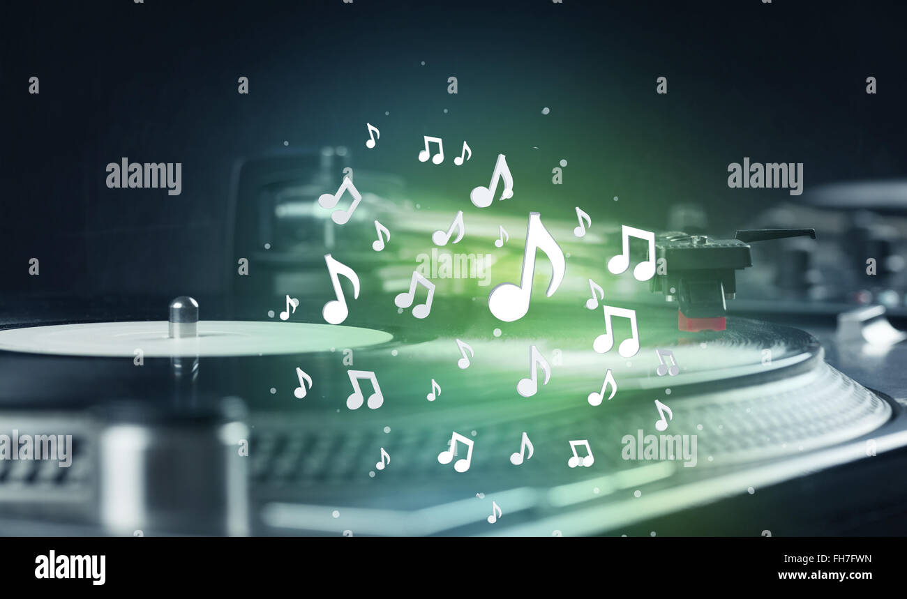 Turntable playing music with audio notes glowing Stock Photo - Alamy