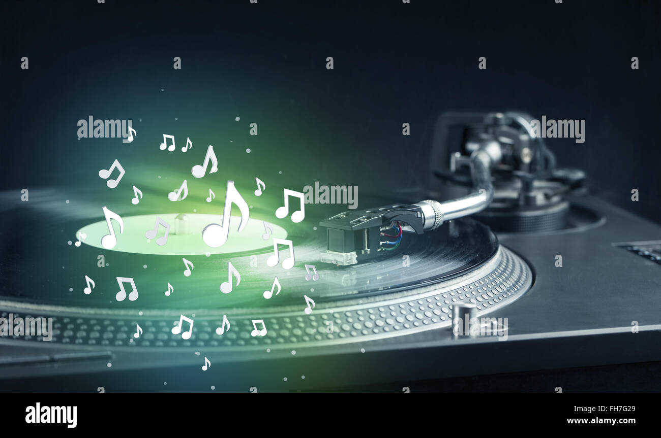 Turntable playing music with audio notes glowing Stock Photo - Alamy