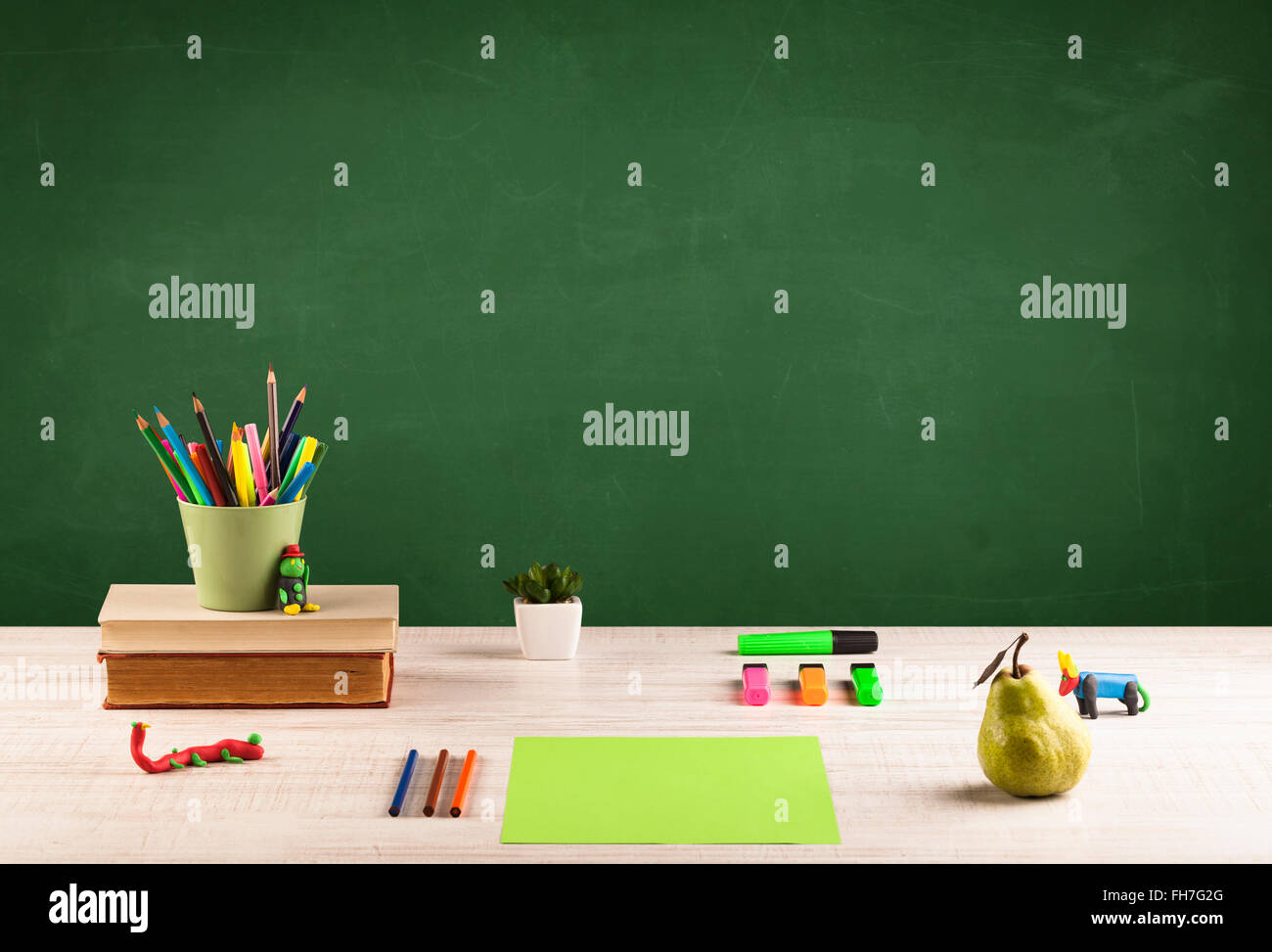 School items on desk with empty chalkboard Stock Photo - Alamy