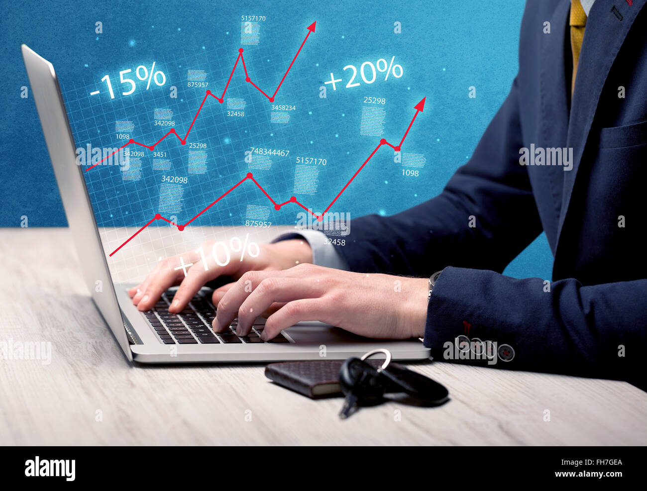 Salesman working on graph with laptop Stock Photo - Alamy