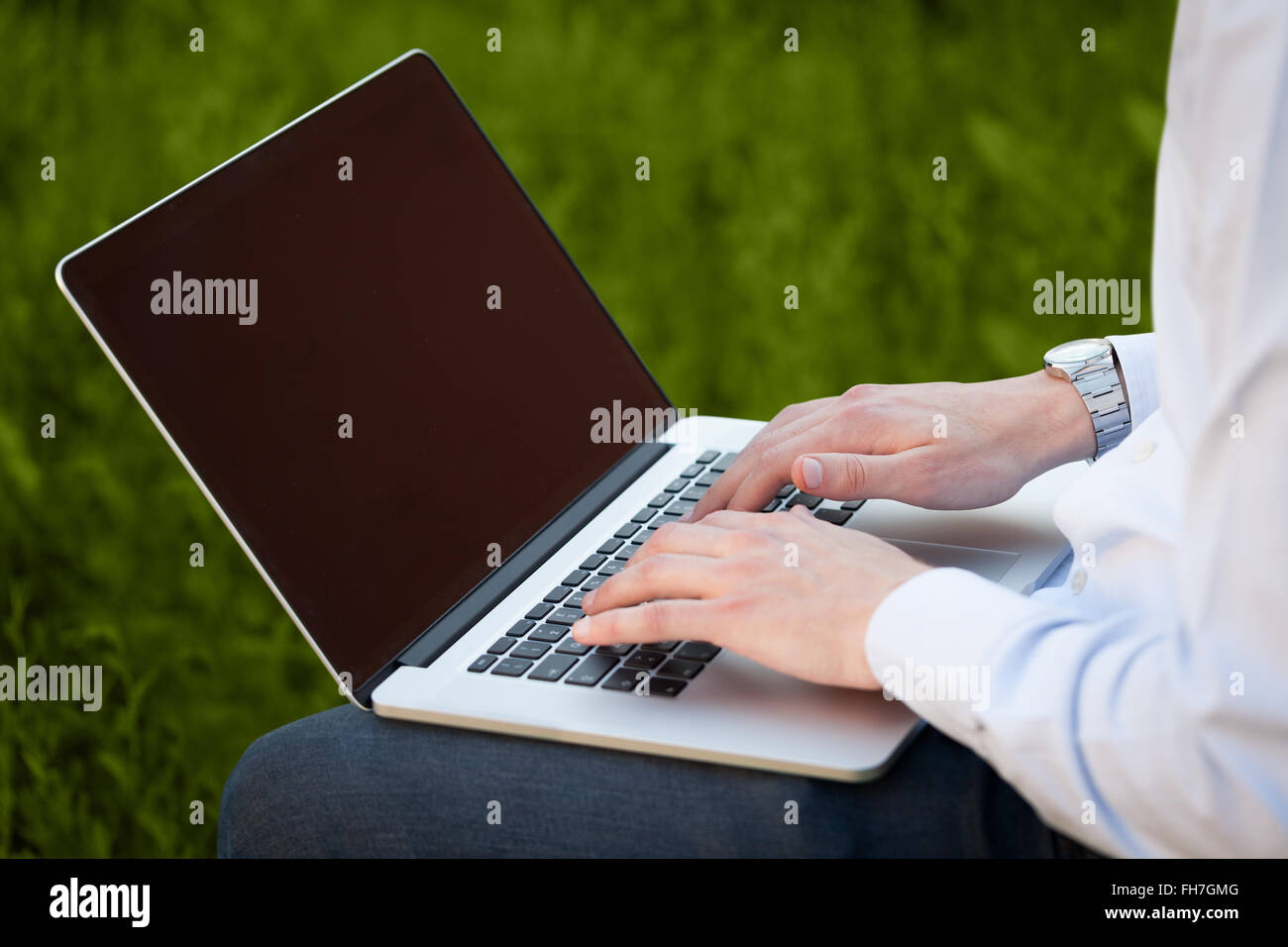 Businessman pressing modern laptop computer on colorful background ...