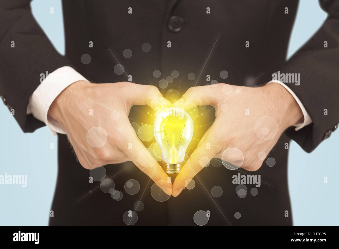 Hands creating a form with light bulb Stock Photo - Alamy