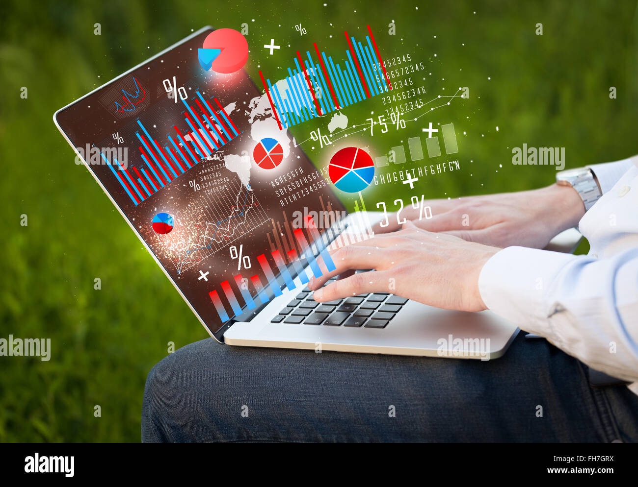 Hand typing on modern laptop notebook computer with graph icons and ...