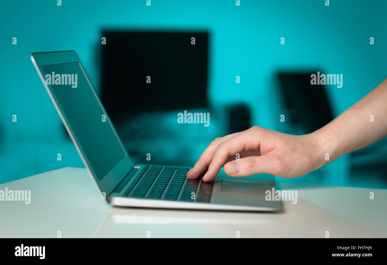 Businessman pressing modern laptop computer on colorful background ...