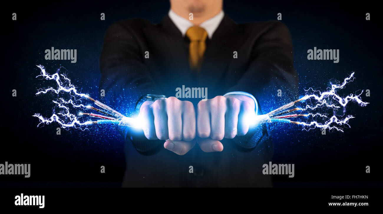 Business person holding electrical powered wires Stock Photo - Alamy