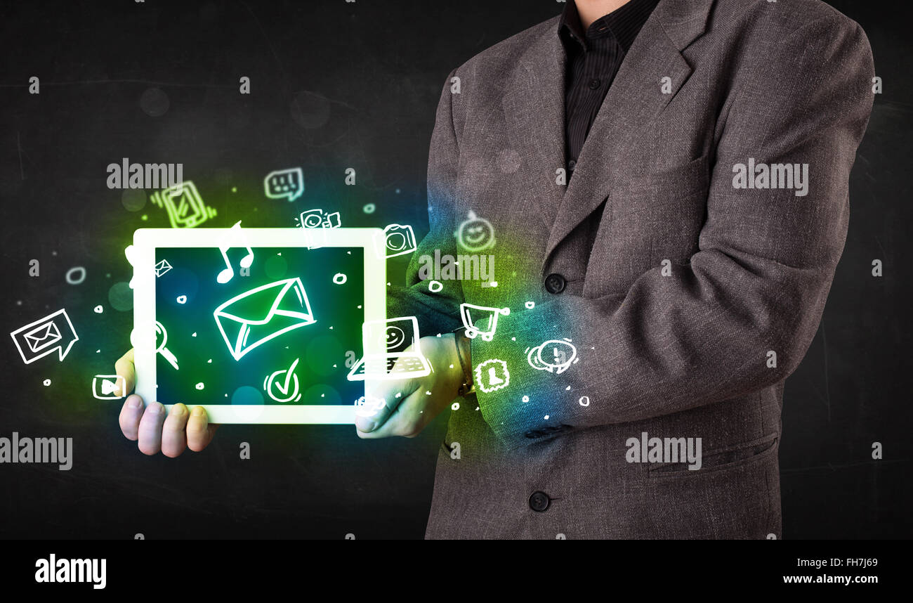 Person holding a tablet with media icons and symbols Stock Photo - Alamy