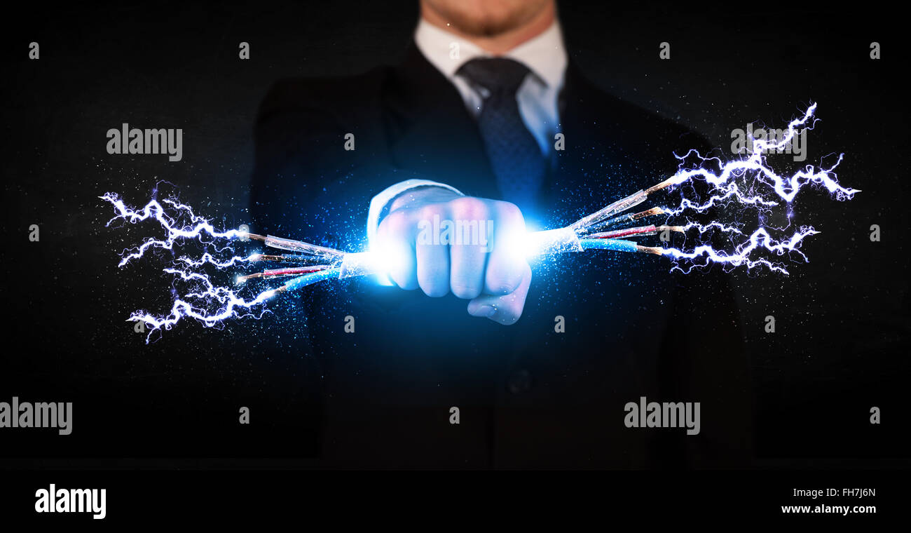 Business person holding electrical powered wires Stock Photo - Alamy