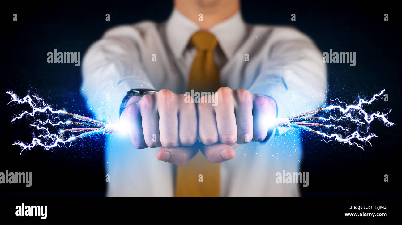 Business person holding electrical powered wires Stock Photo - Alamy