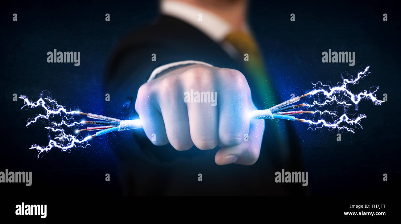 Business person holding electrical powered wires Stock Photo - Alamy