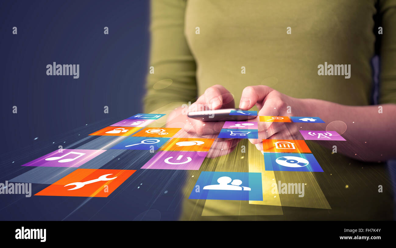 Woman holding smart phone with colorful application icons Stock Photo ...