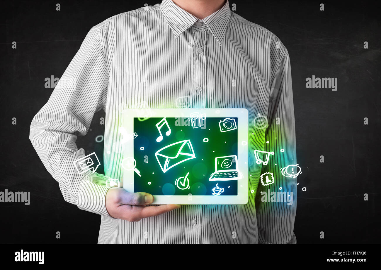 Person holding a tablet with media icons and symbols Stock Photo - Alamy